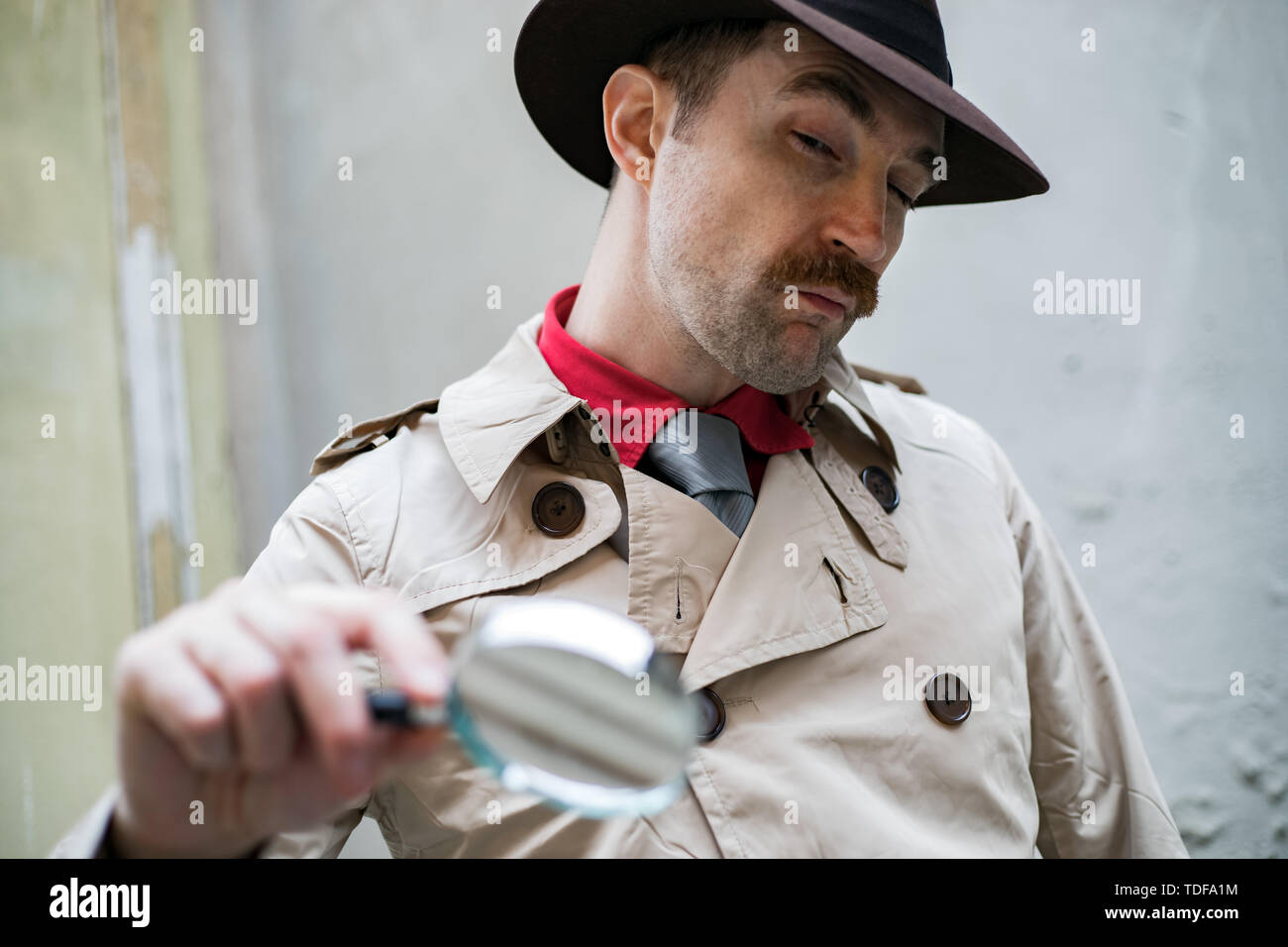 Detective using a magnify lens Stock Photo - Alamy