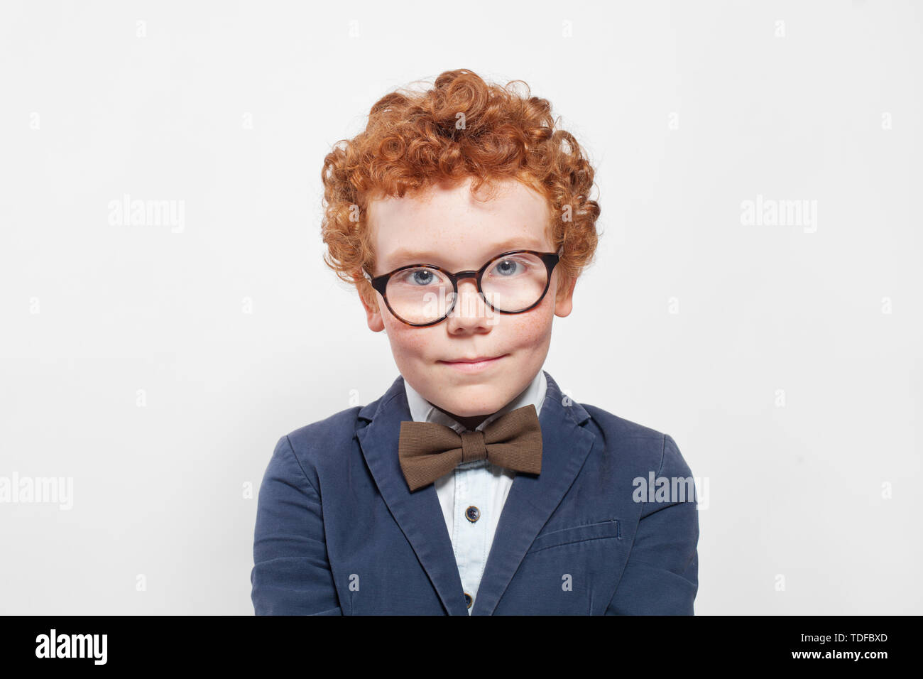 Redhead boy in blue suit with bow tie on white Stock Photo - Alamy