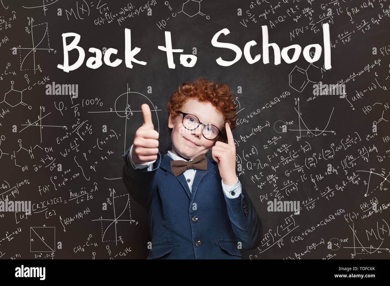 Clever boy student with Back to school text on chalkboard background in ...