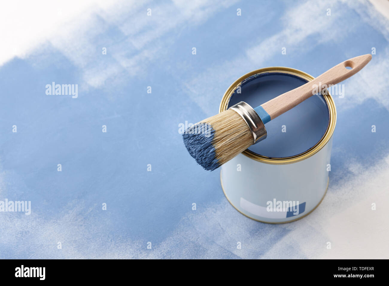 Brush and can of blue paint on painted surface with strokes Stock Photo ...