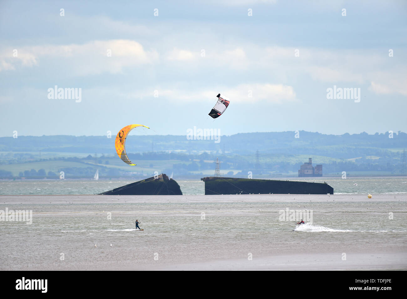 Kite surfers pass a Mulberry Harbour in the Thames Estuary off Southend ...