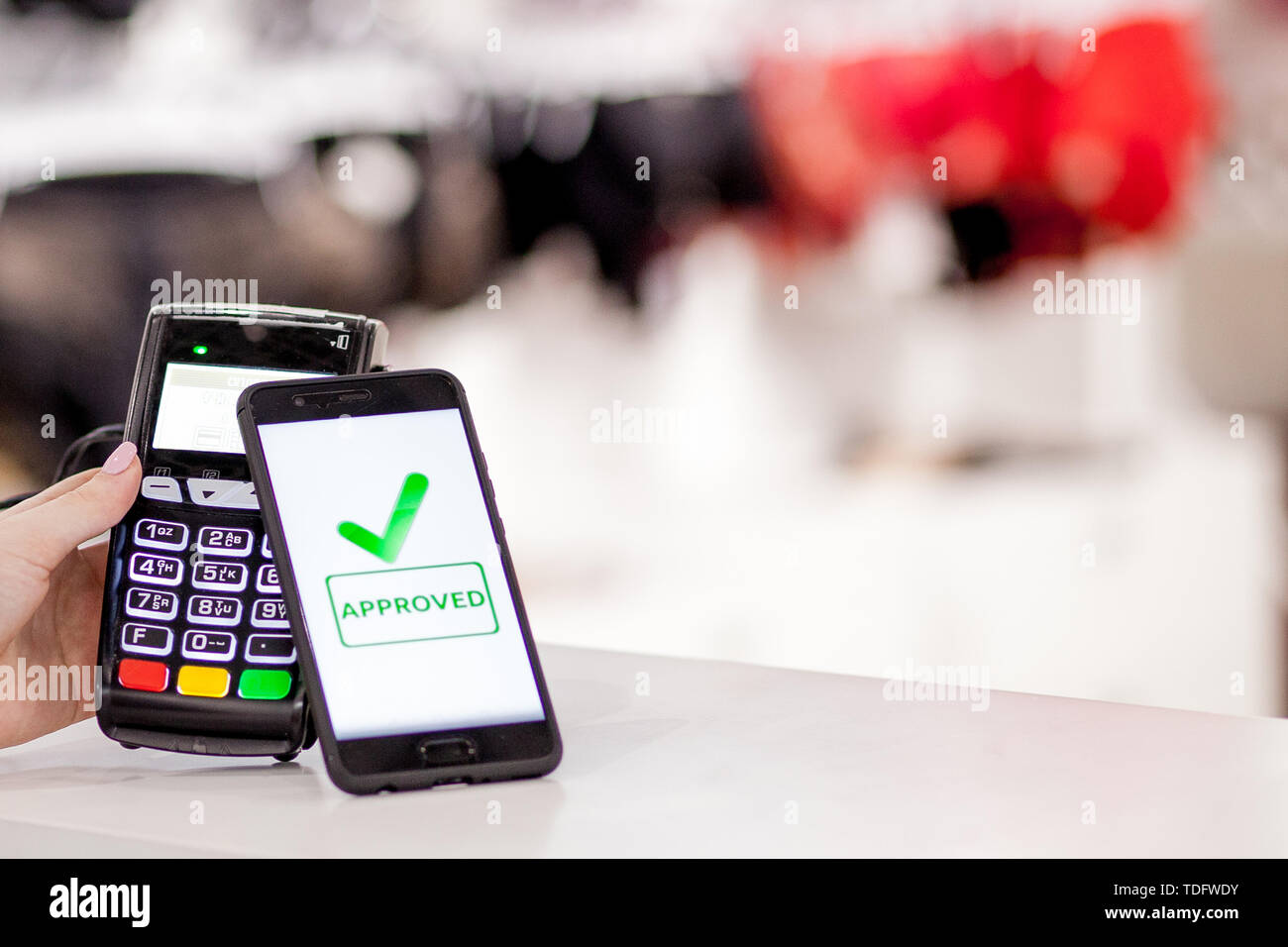 POS terminal, Payment Machine with mobile phone on store background ...