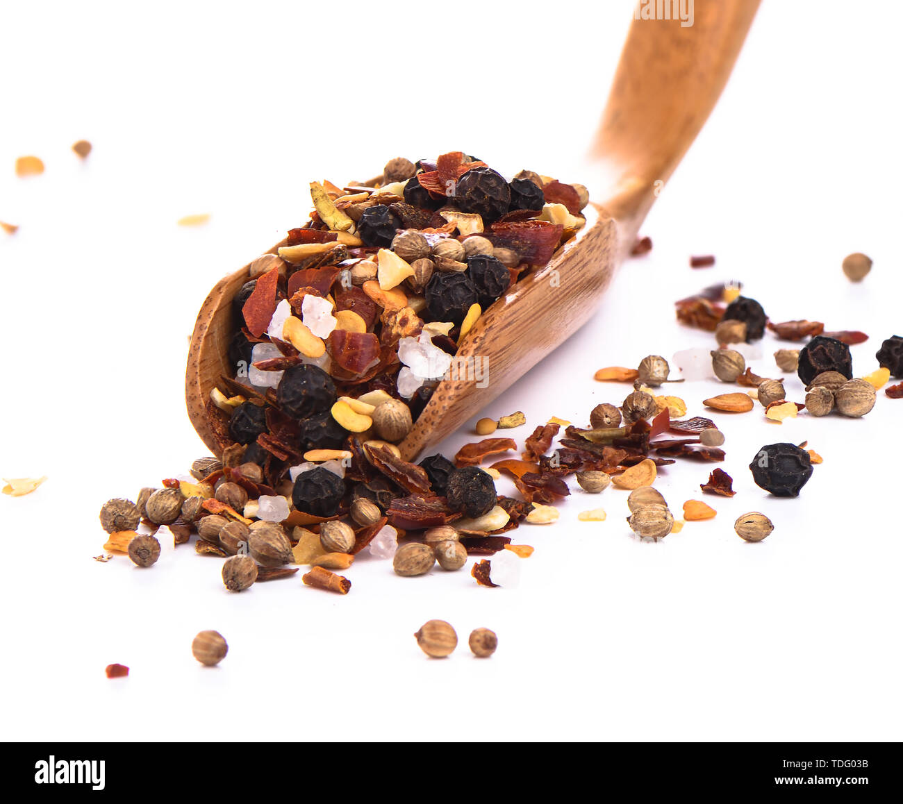 Mixture of spices for culinary mill on wooden scoop isolated on white ...