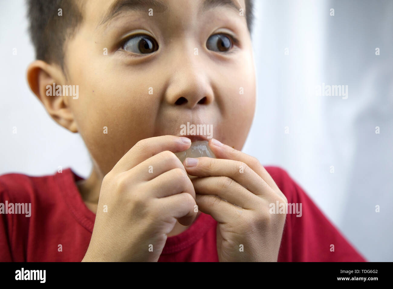 Boy eating lychee close-up Stock Photo - Alamy