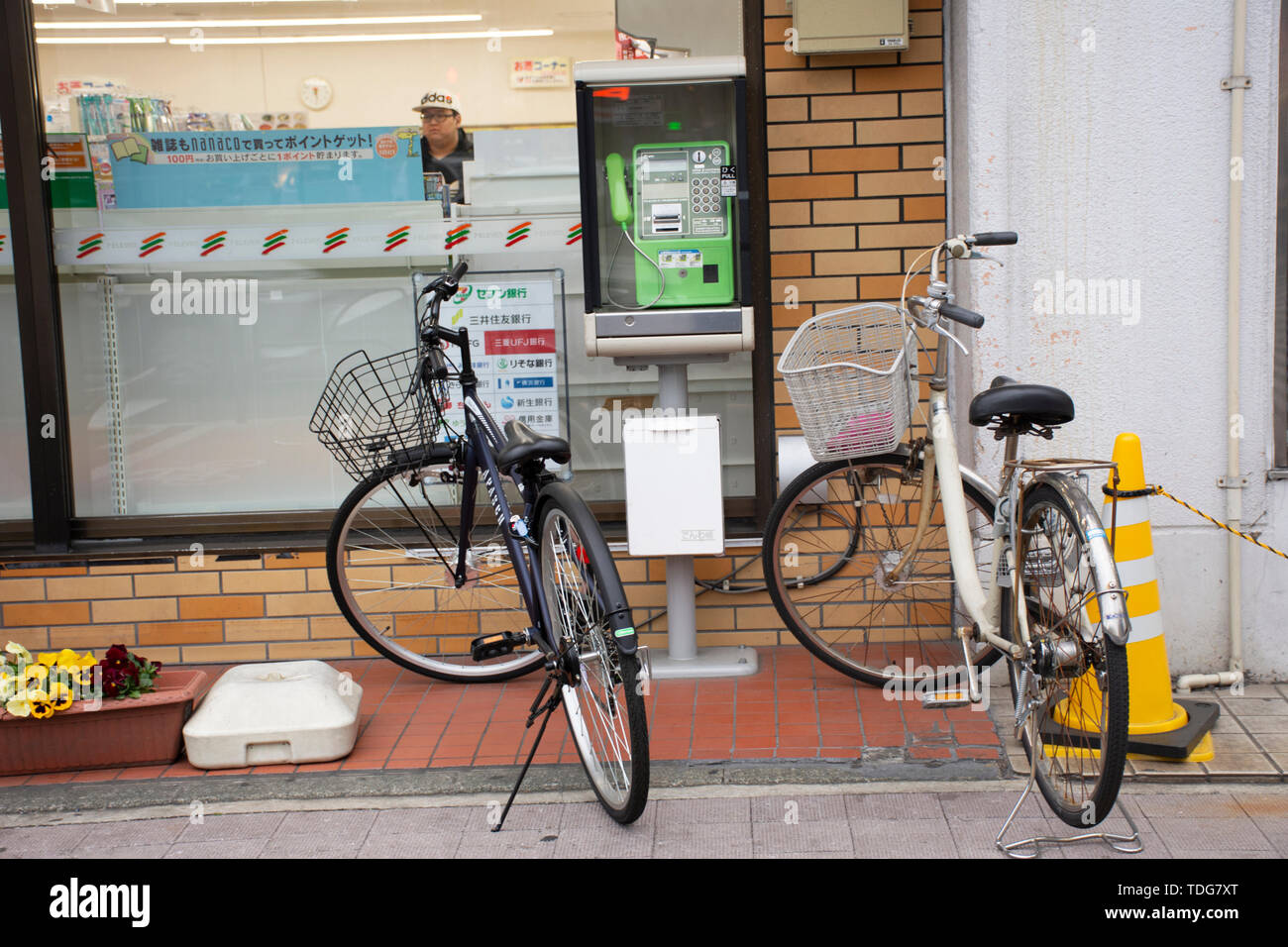 Japanese people stop bicycle at front of convenience store with public ...