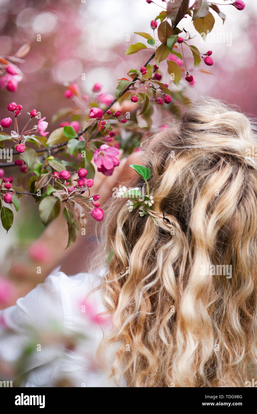 portraits of a beautiful girl in spring park with trees in flowers ...