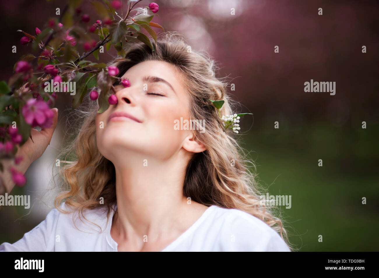portraits of a beautiful girl in spring park with trees in flowers ...