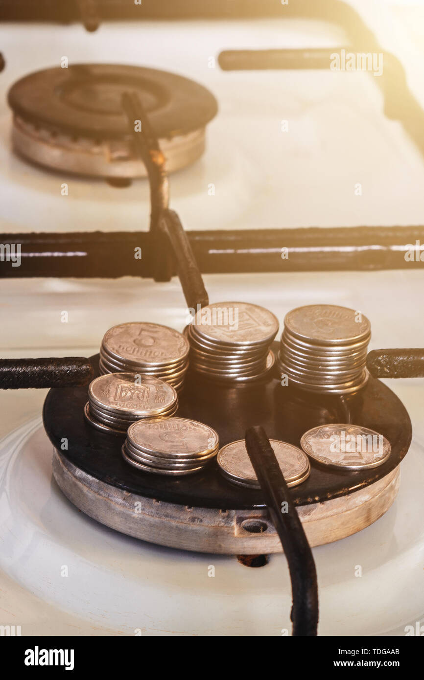 Coins are scattered and laid out on a pyramid on a gas stove, gas is ...