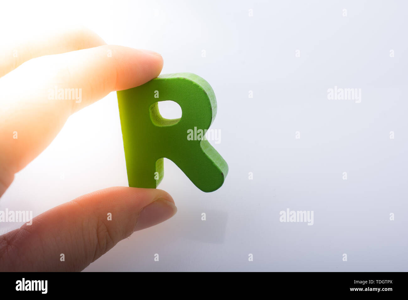 Hand holding letter cube R of made of wood Stock Photo - Alamy