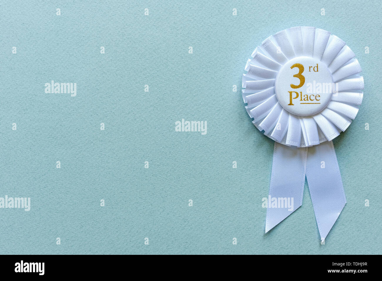 3rd Place white ribbon rosette with gold text for a competition runner ...