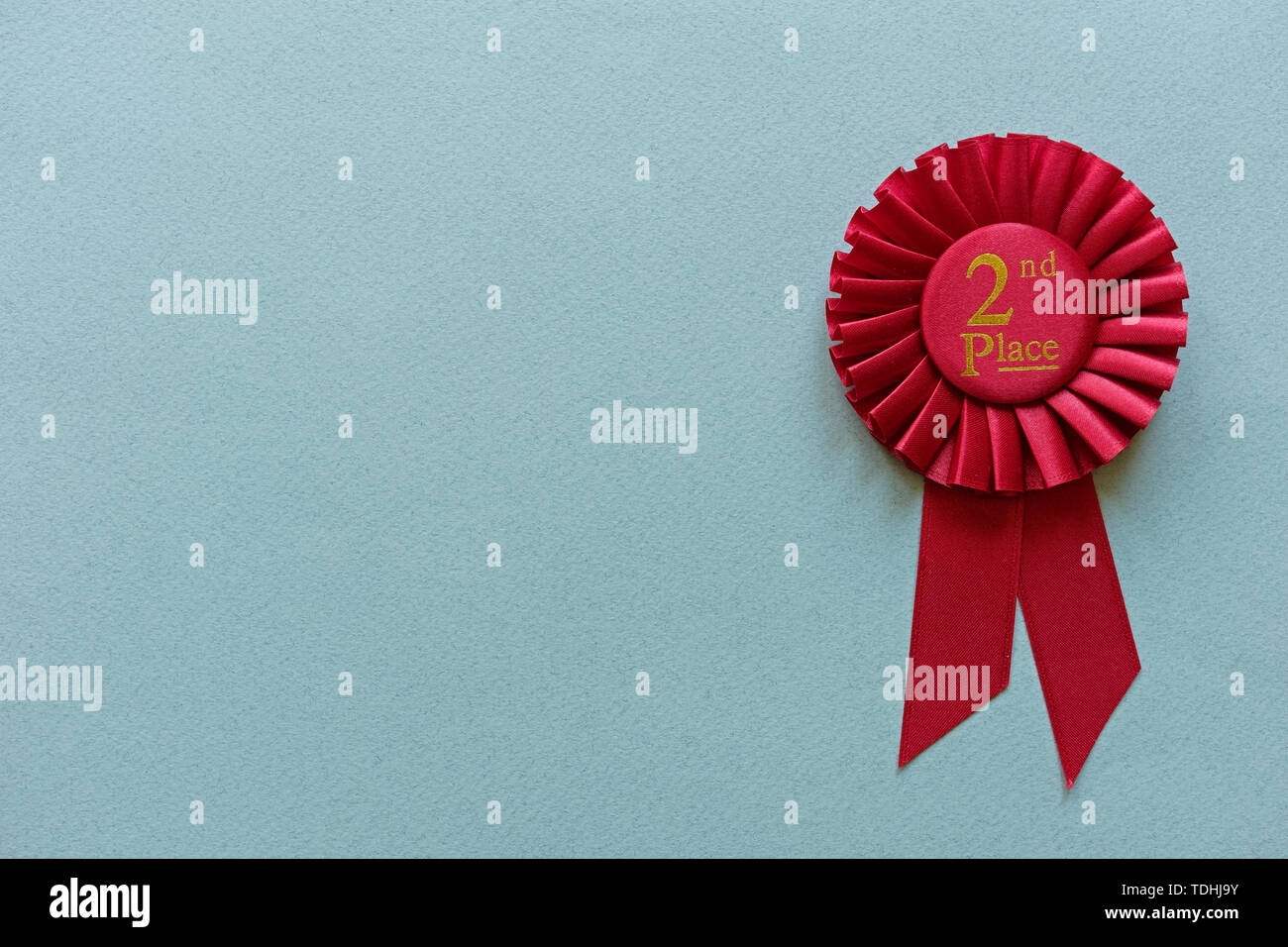 Red 2nd Place Winners rosette on light blue background with lateral ...
