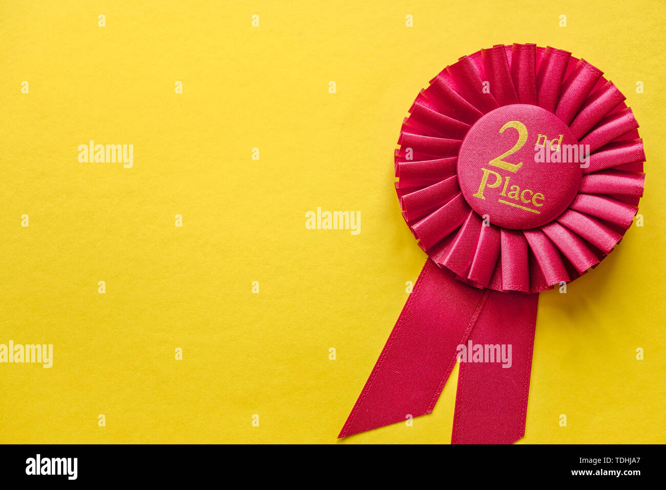 2nd Place red winners ribbon rosette on a colorful yellow background ...