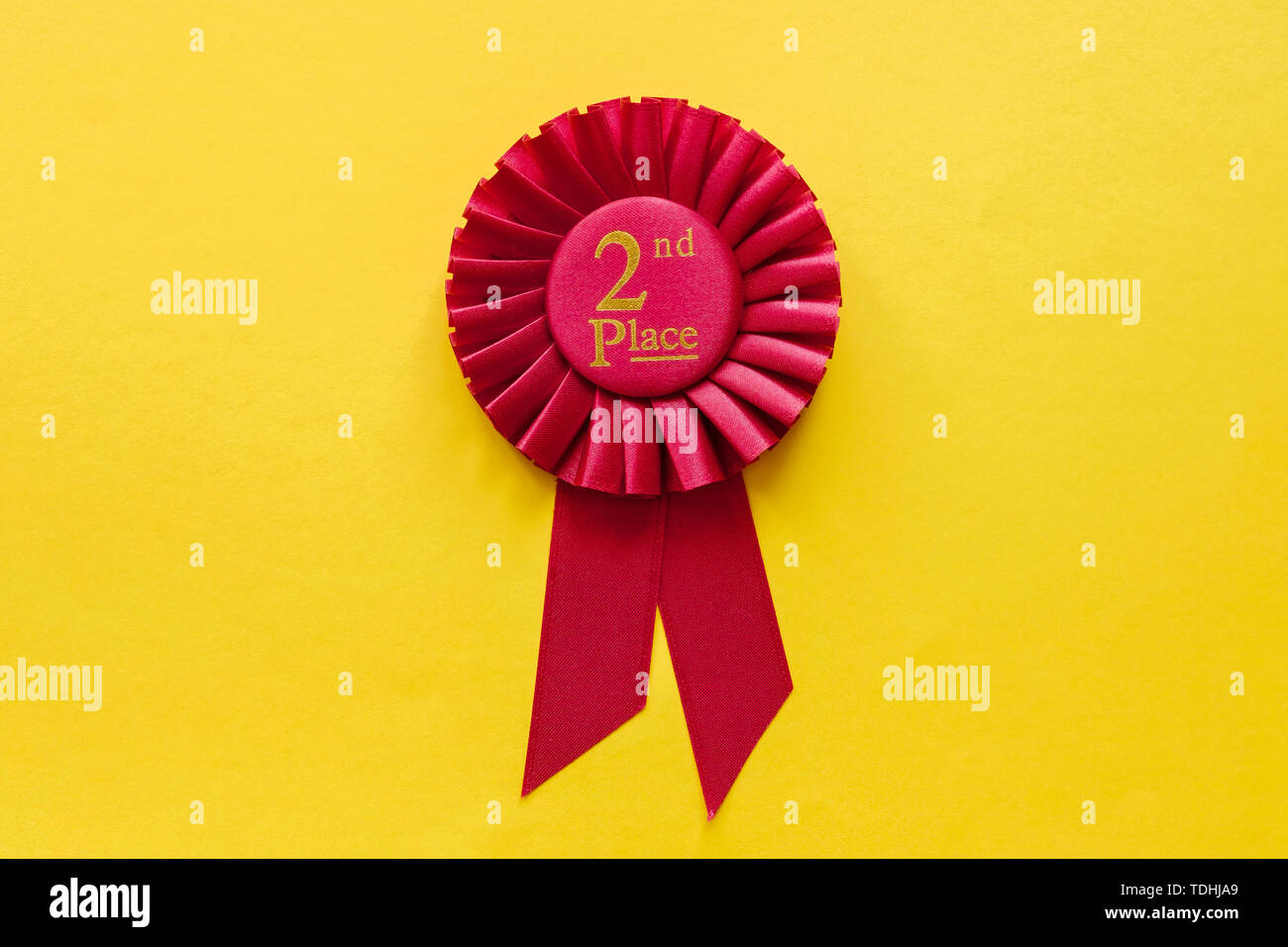 2nd Place red winners ribbon rosette on a colorful yellow background ...