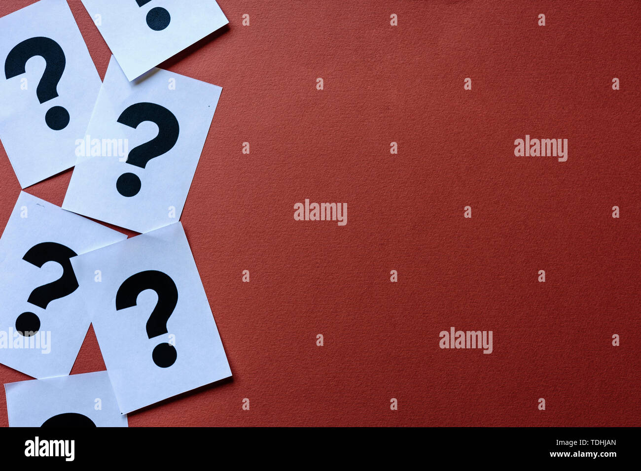 Border of printed question marks on white cards to the side over a ...