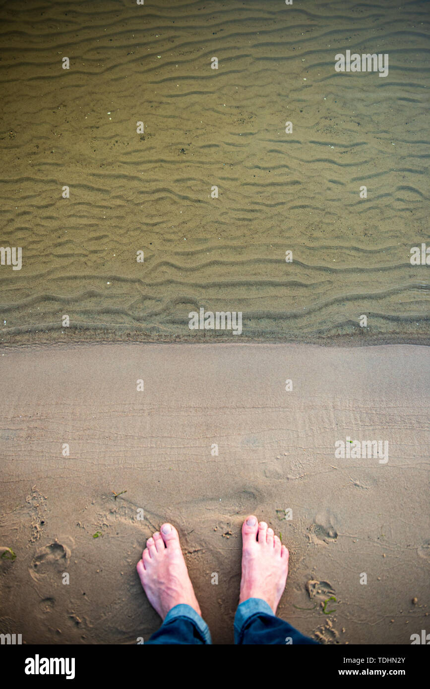 human feet standing on the sand or ground soil in nature textured ...