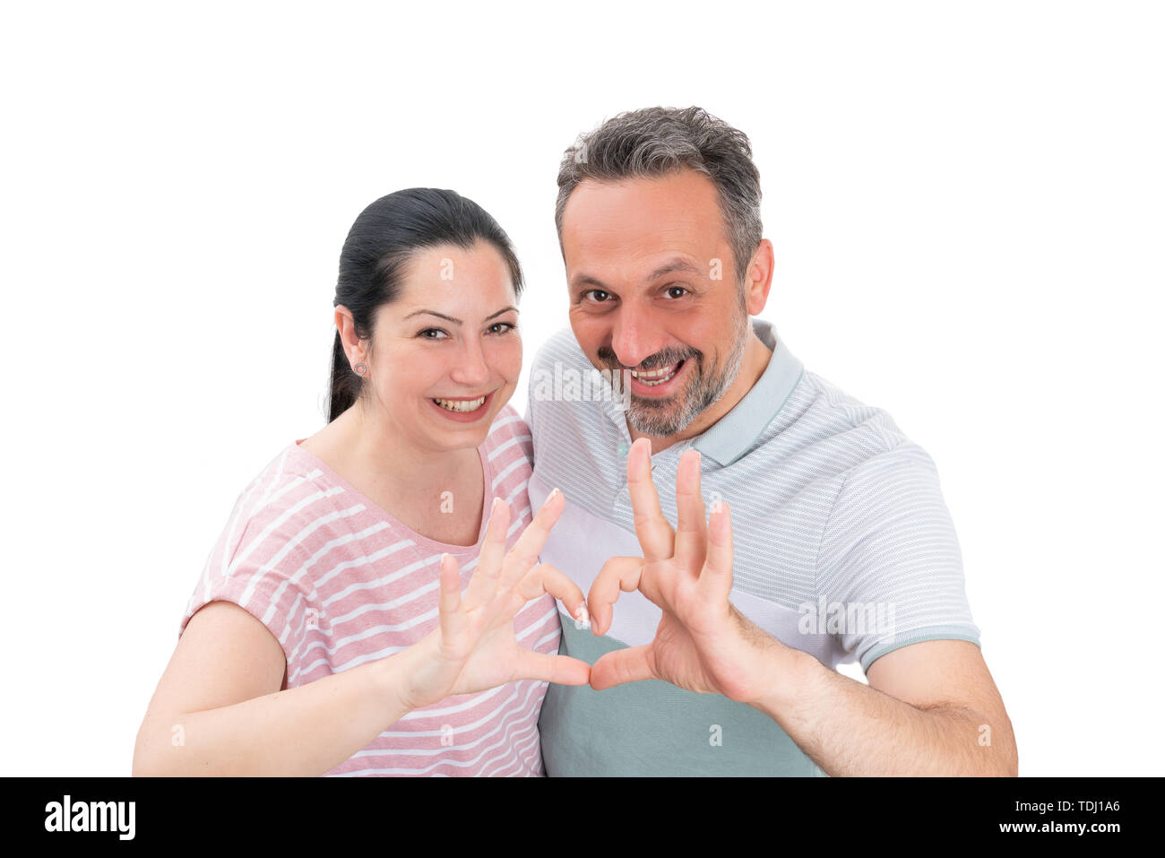 Cheerful man and woman couple making heart gesture with fingers as love ...