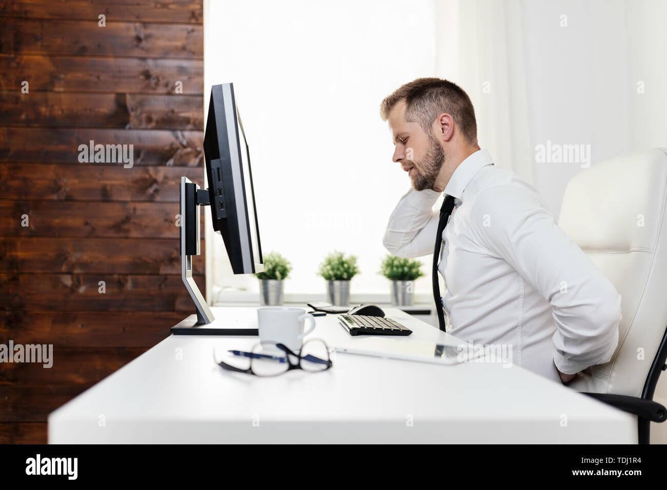 Office worker with back pain from sitting at desk all day Stock Photo ...