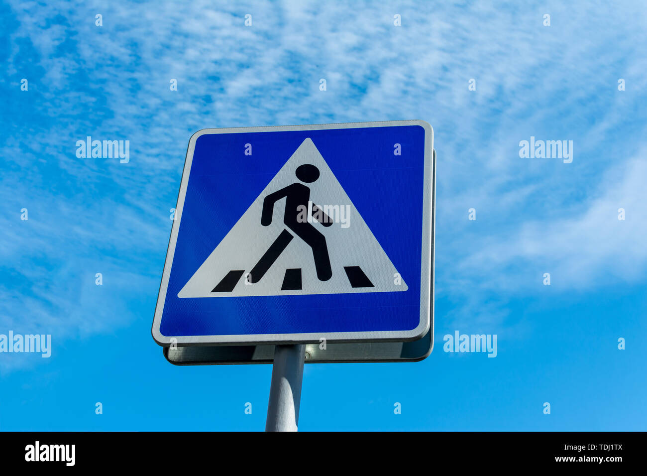 Road safety concept - blue pedestrian crossing sign close up against a ...