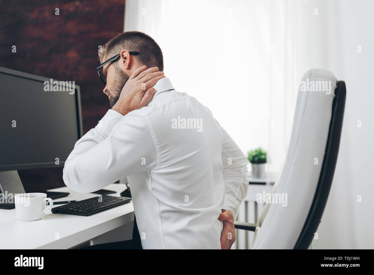 Office worker with back pain from sitting at desk all day Stock Photo ...