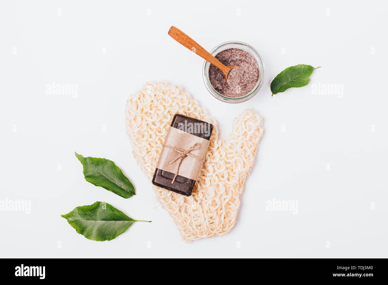 Flat lay composition of massage mitten, natural soap and coffee body ...