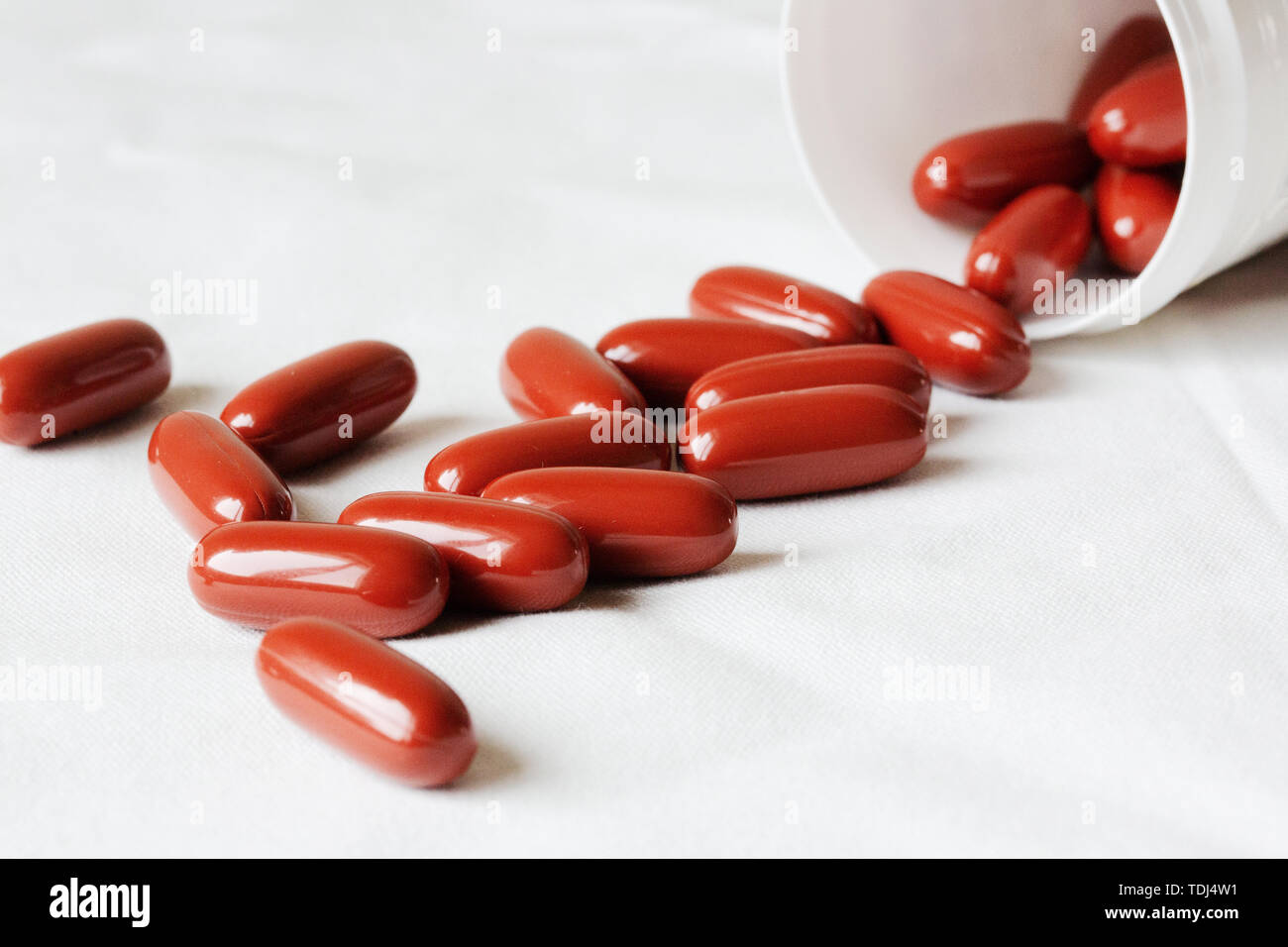 Red pill on white background Stock Photo - Alamy