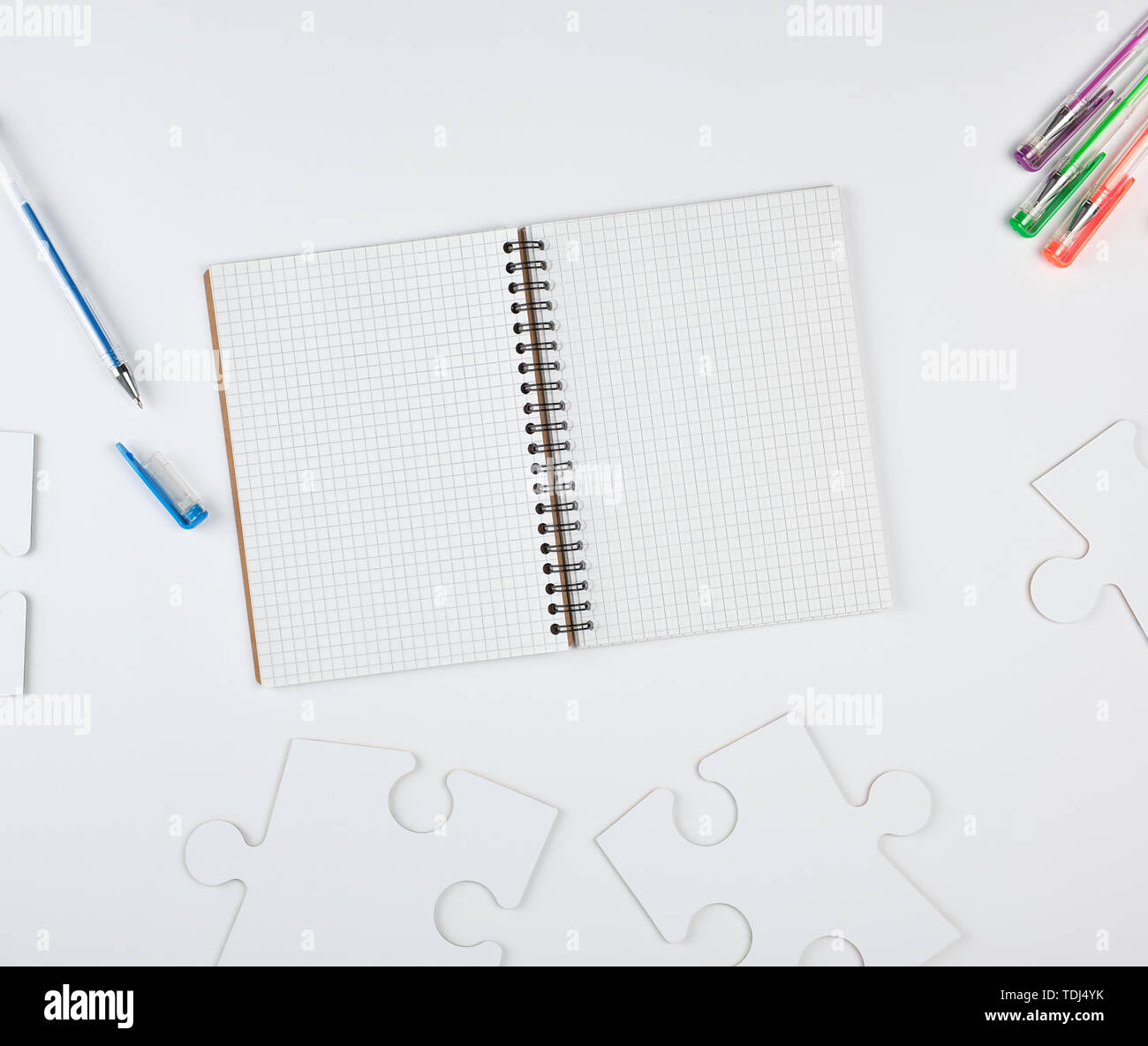 open notebook in a cell and on a white background, next to large blank ...