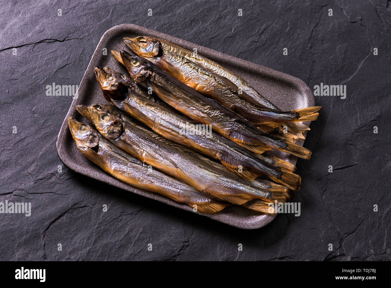 Close up. Dark background. Smoked fish capelin on the table Stock Photo ...