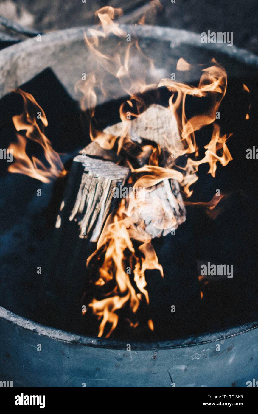 Close up shot of pieces of wood burning with fire in a large pot Stock ...