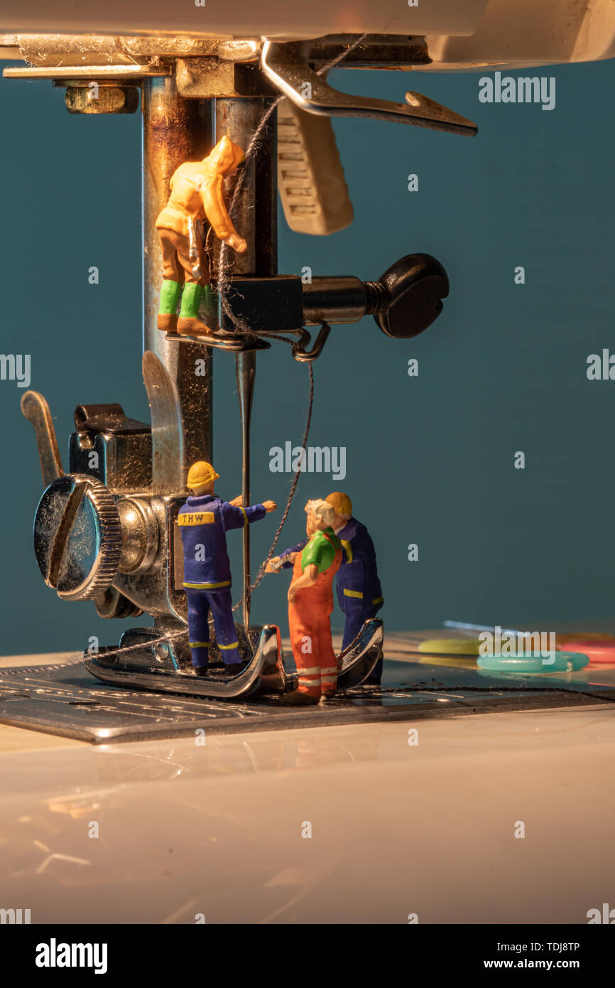 miniature people change thread on sewing machine Stock Photo - Alamy