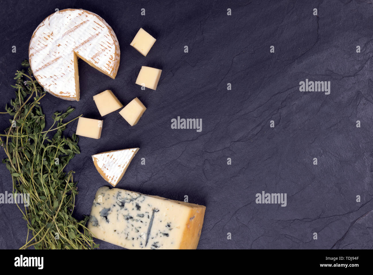 Cheese with mold with a sprig of thyme on a slate Board Stock Photo - Alamy