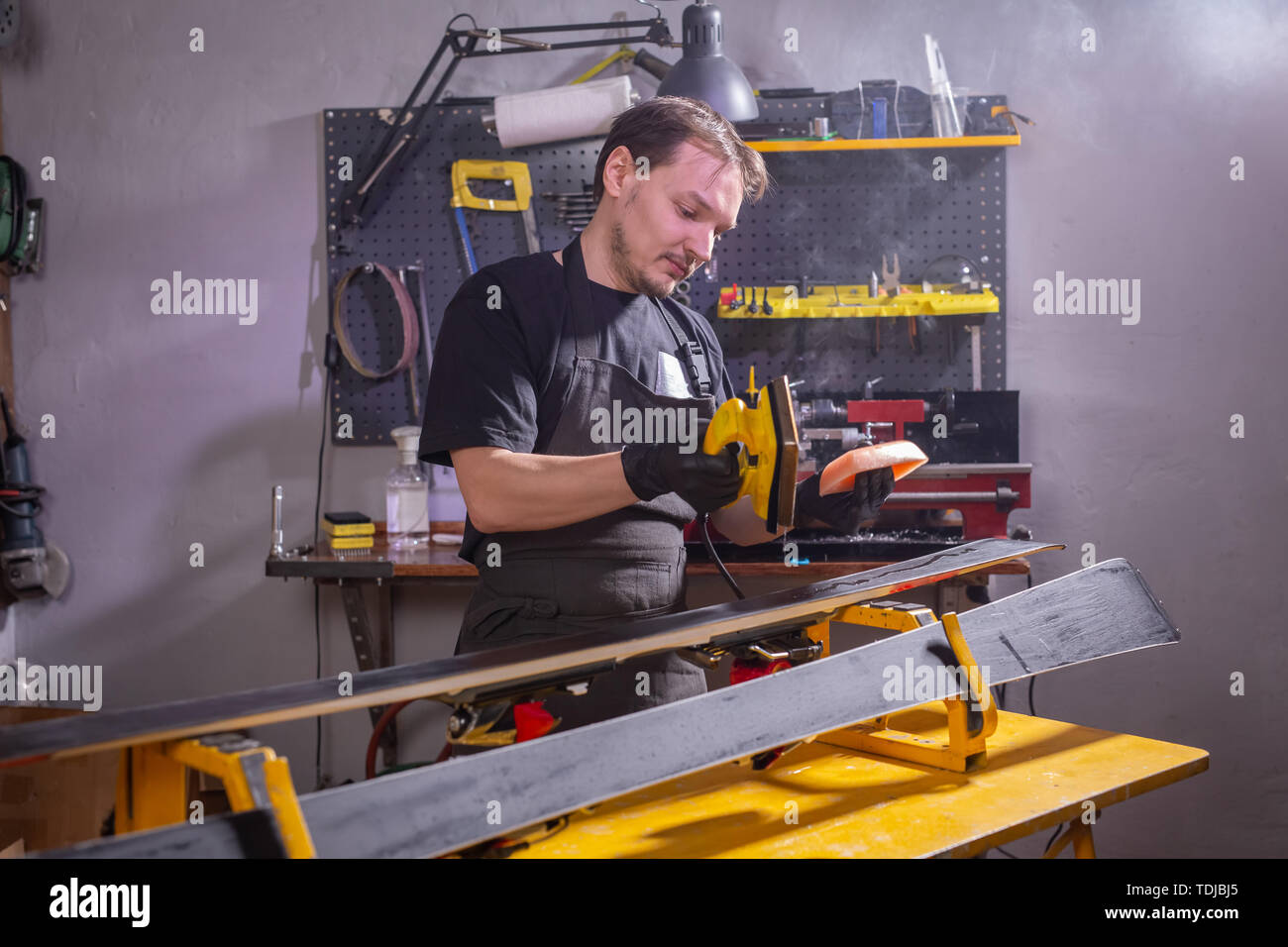 Repair, people concept - mechanic, man is rubbing a ski Stock Photo - Alamy