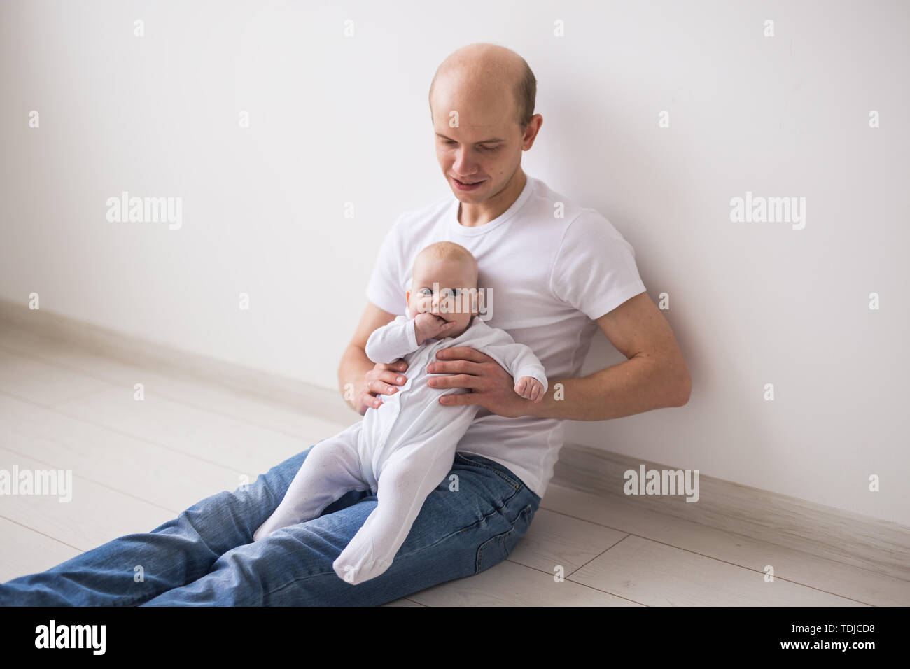 Infant, family and children concept - Bald father takes care of his ...