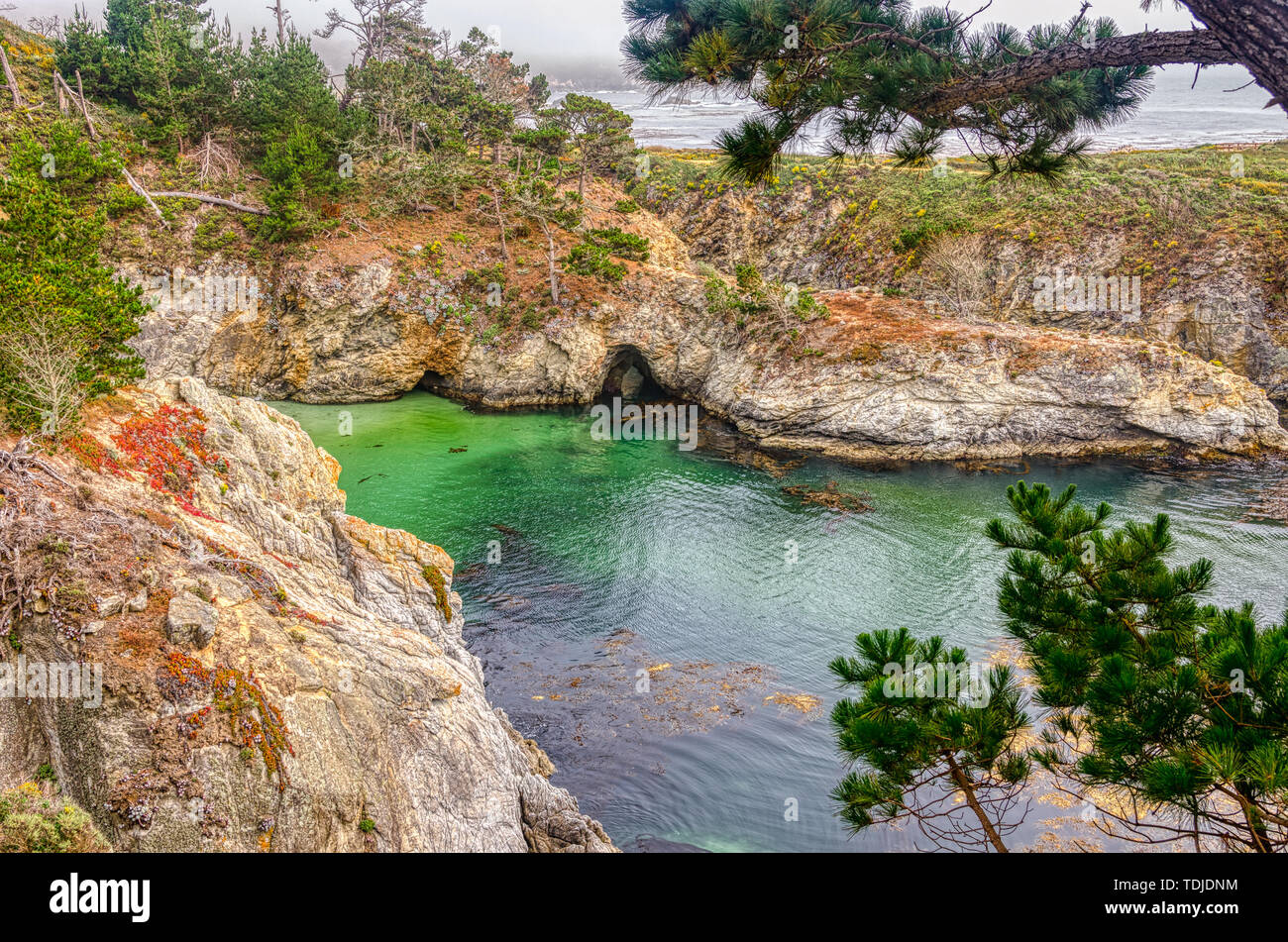 Green and blue waters meet the shoreline of bluffs forming a natural ...