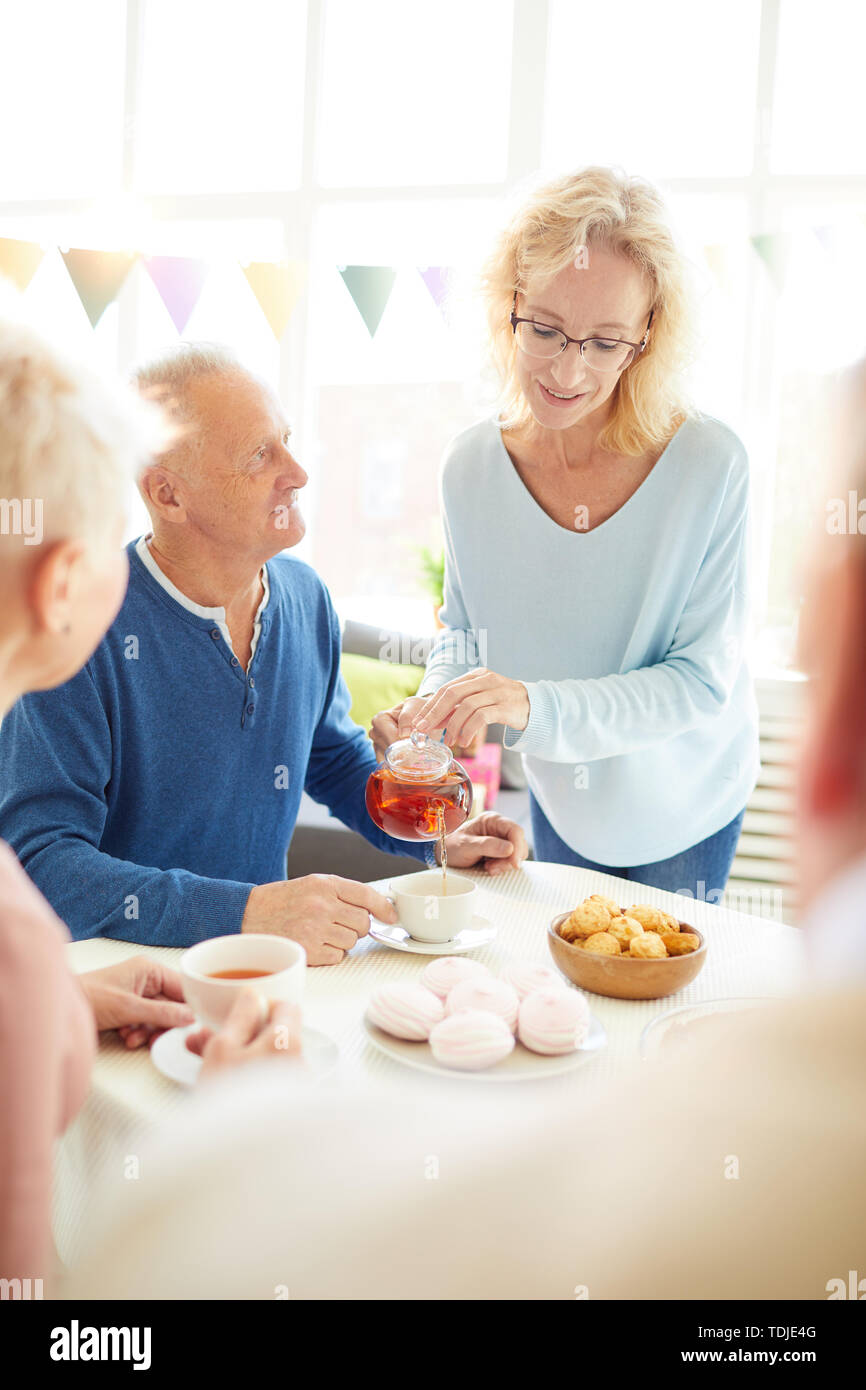 Positive attractive woman in glasses standing at dining table and ...