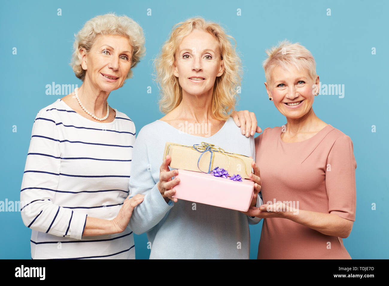 Portrait of smiling beautiful mature lady standing with best friends ...