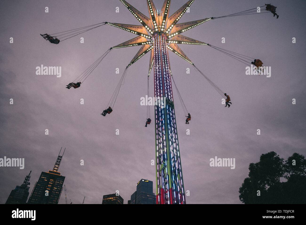 People having fun on large tall colorful swings Stock Photo - Alamy
