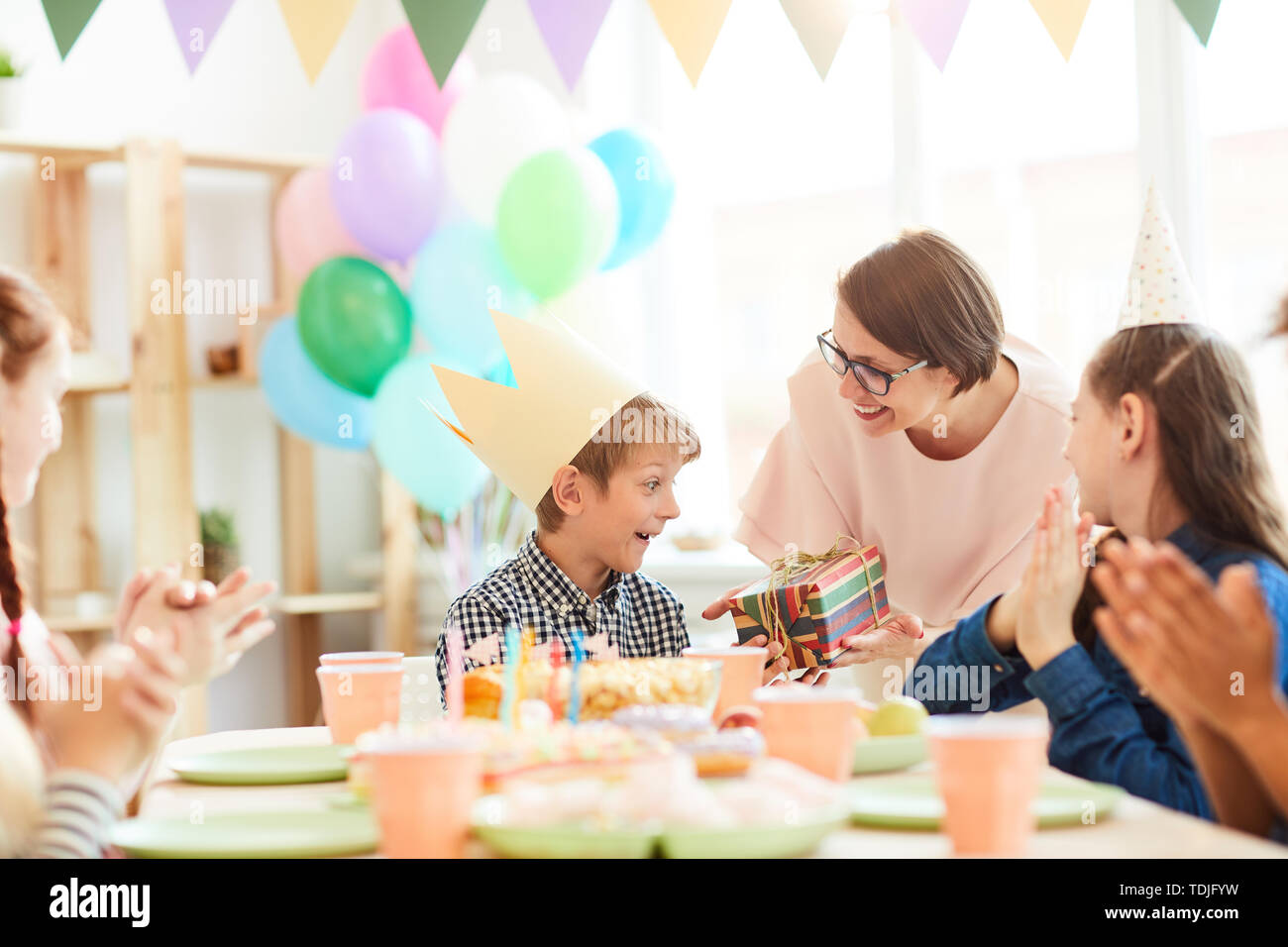 Portrait of excited boy receiving gifts during Birthday party with ...