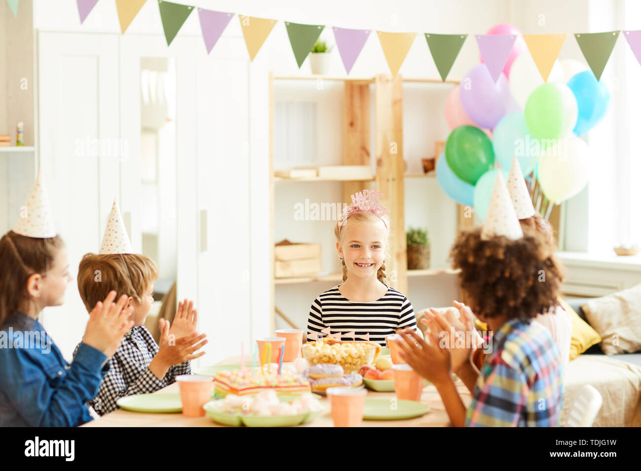 Group of children at Birthday party, focus on cute little girl sitting ...