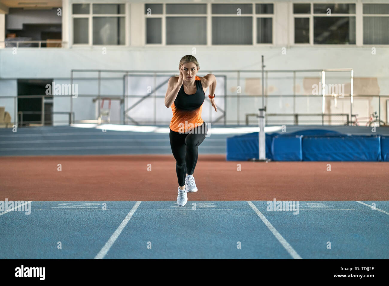 Sportive girl in a black-orange T-shirt with dark pants and gray ...