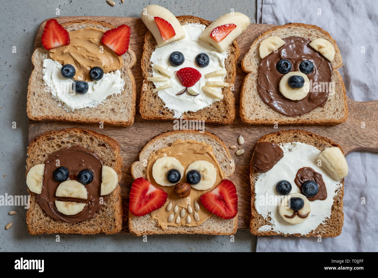 Funny animal faces toasts with spreads, banana, strawberry and ...