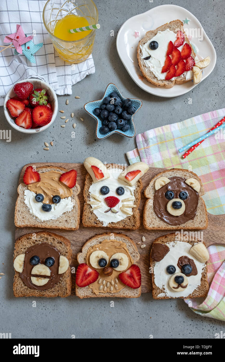 Funny animal faces toasts with spreads, banana, strawberry and ...