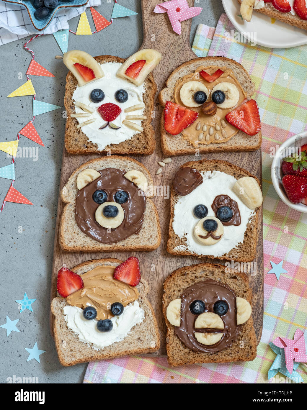 Funny animal faces toasts with spreads, banana, strawberry and ...