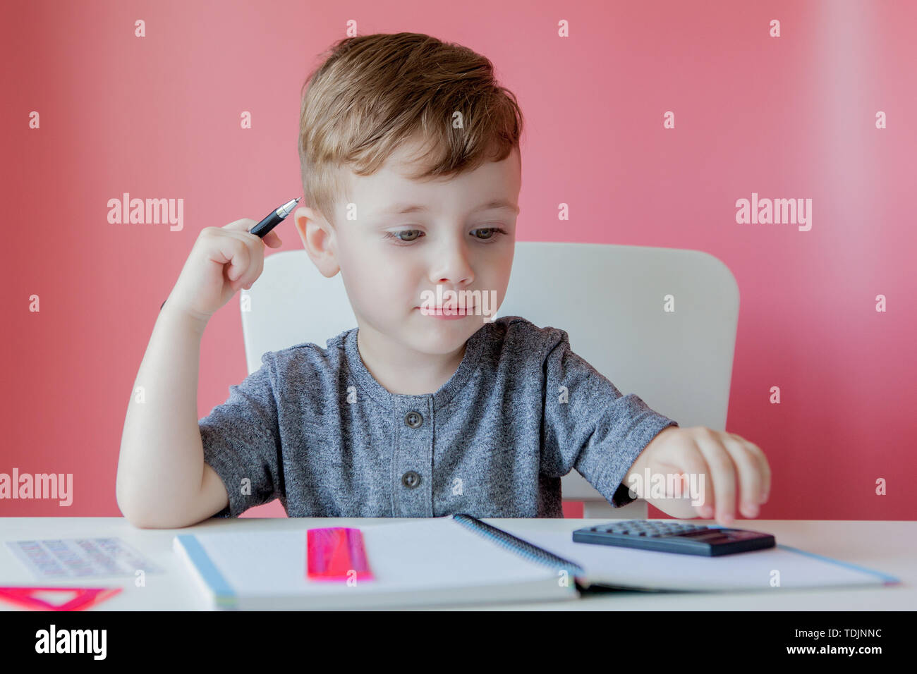 Portrait of cute kid boy at home making homework. Little concentrated ...
