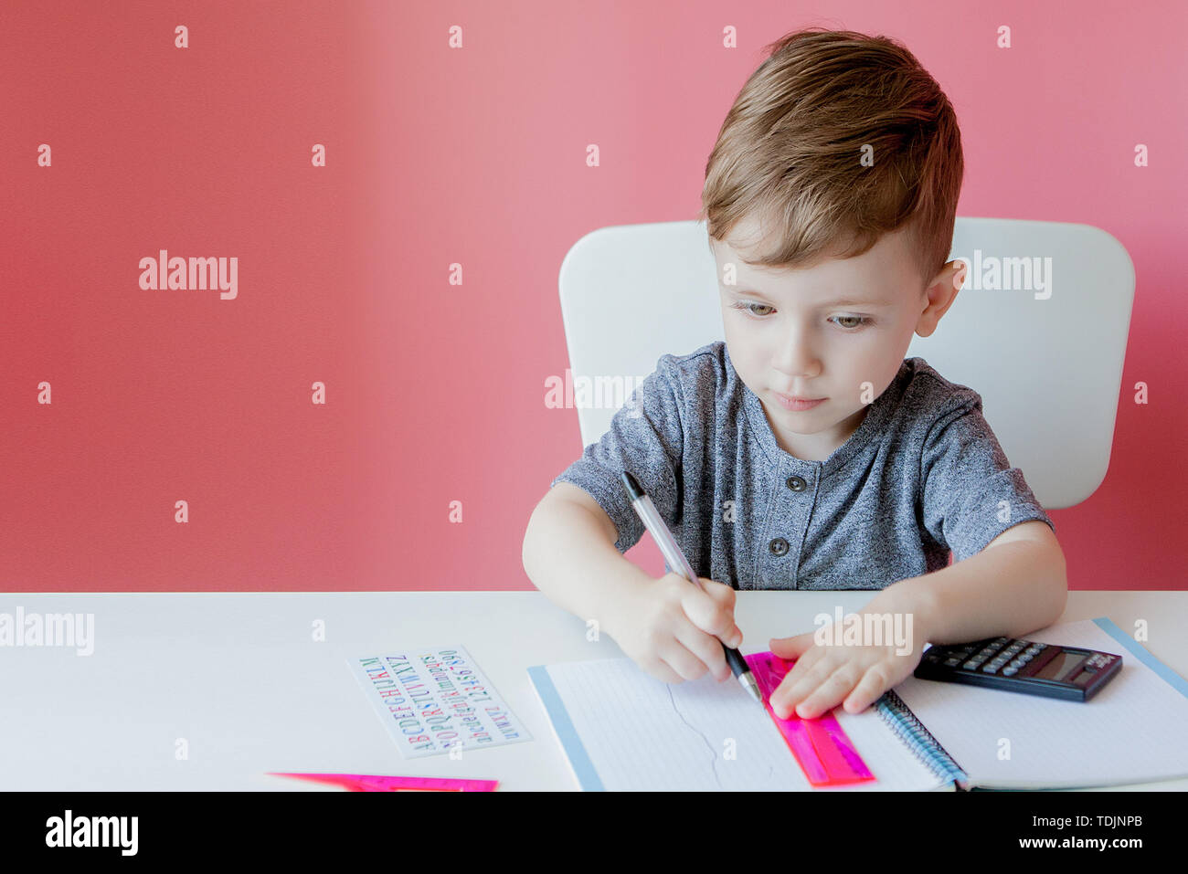 Portrait of cute kid boy at home making homework. Little concentrated ...