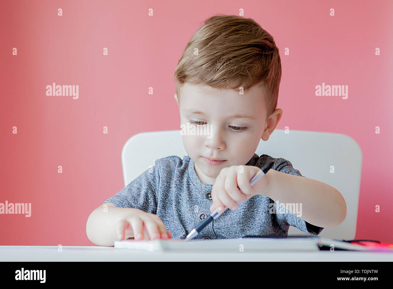 Portrait of cute kid boy at home making homework. Little concentrated ...