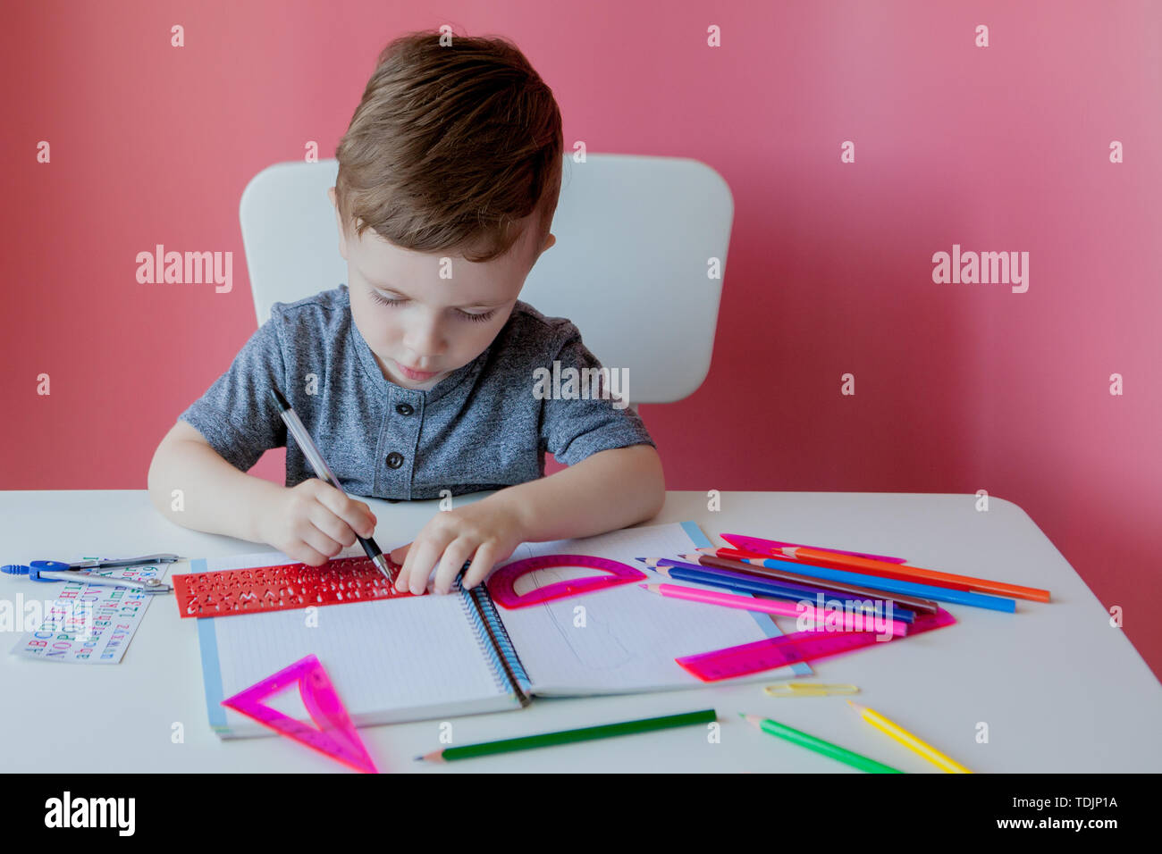 Portrait of cute kid boy at home making homework. Little concentrated ...