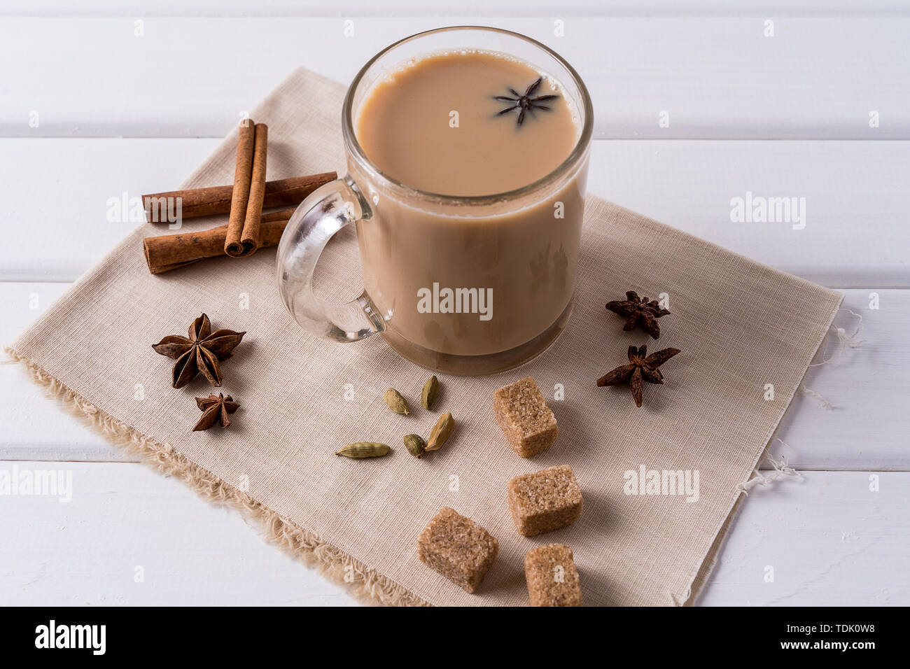 Indian traditional Masala chai tea in a glass mug and kitchen herbs ...
