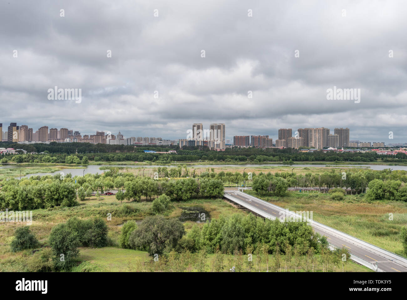 Cloudy weather overlooks riverside green space building Stock Photo - Alamy