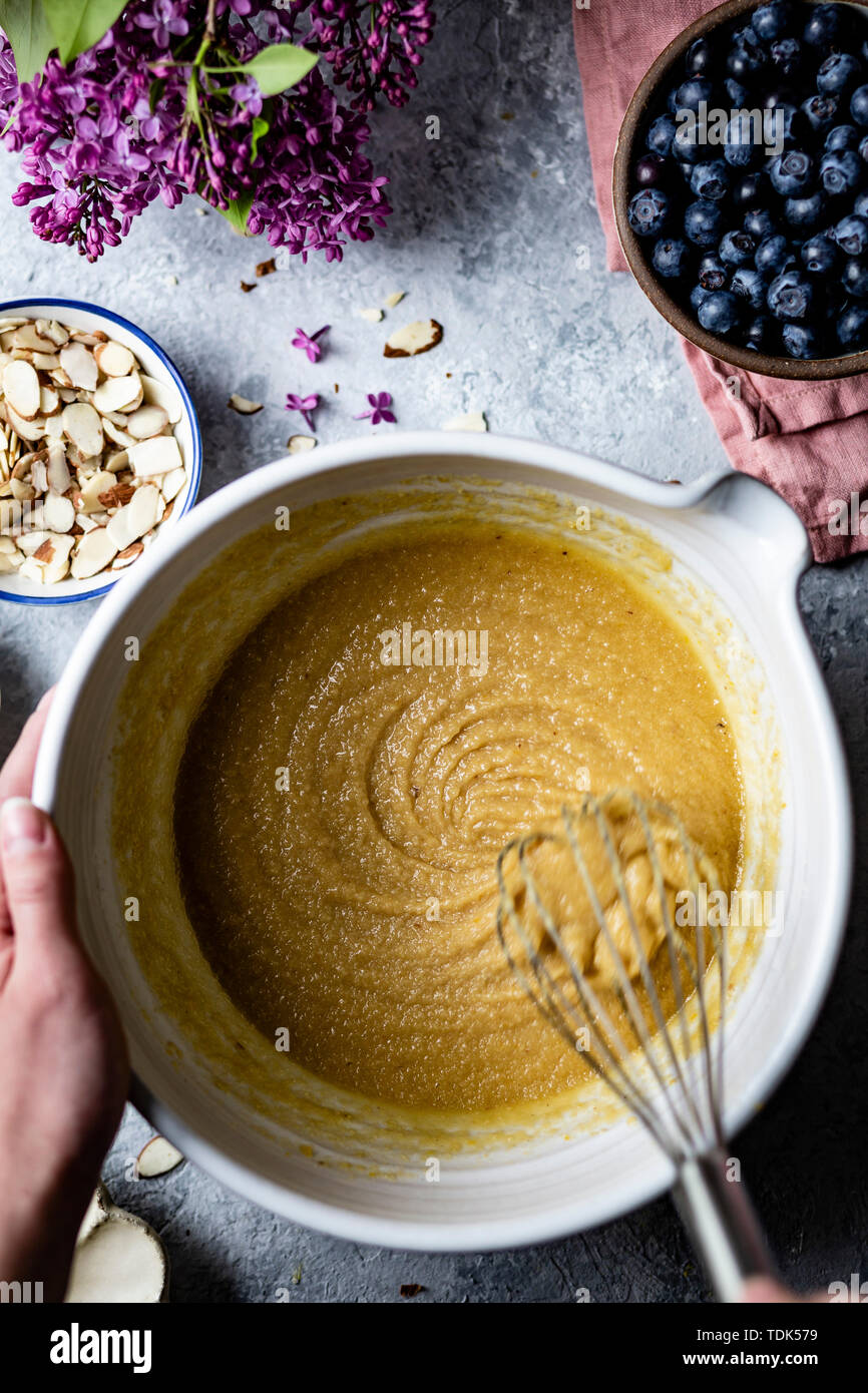 Mixing a cake mixture in a mixing bowl surrounded by ingredients Stock ...