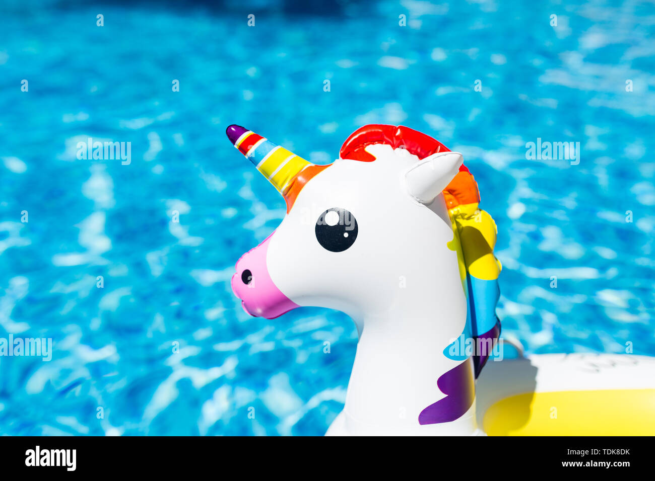 Inflatable colorful white unicorn in the swimming pool. Summer time in ...